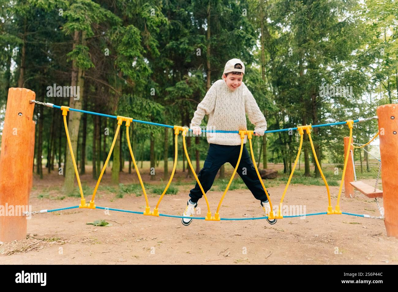 Teen boy playing in a rope town on the playground, obstacles Stock ...