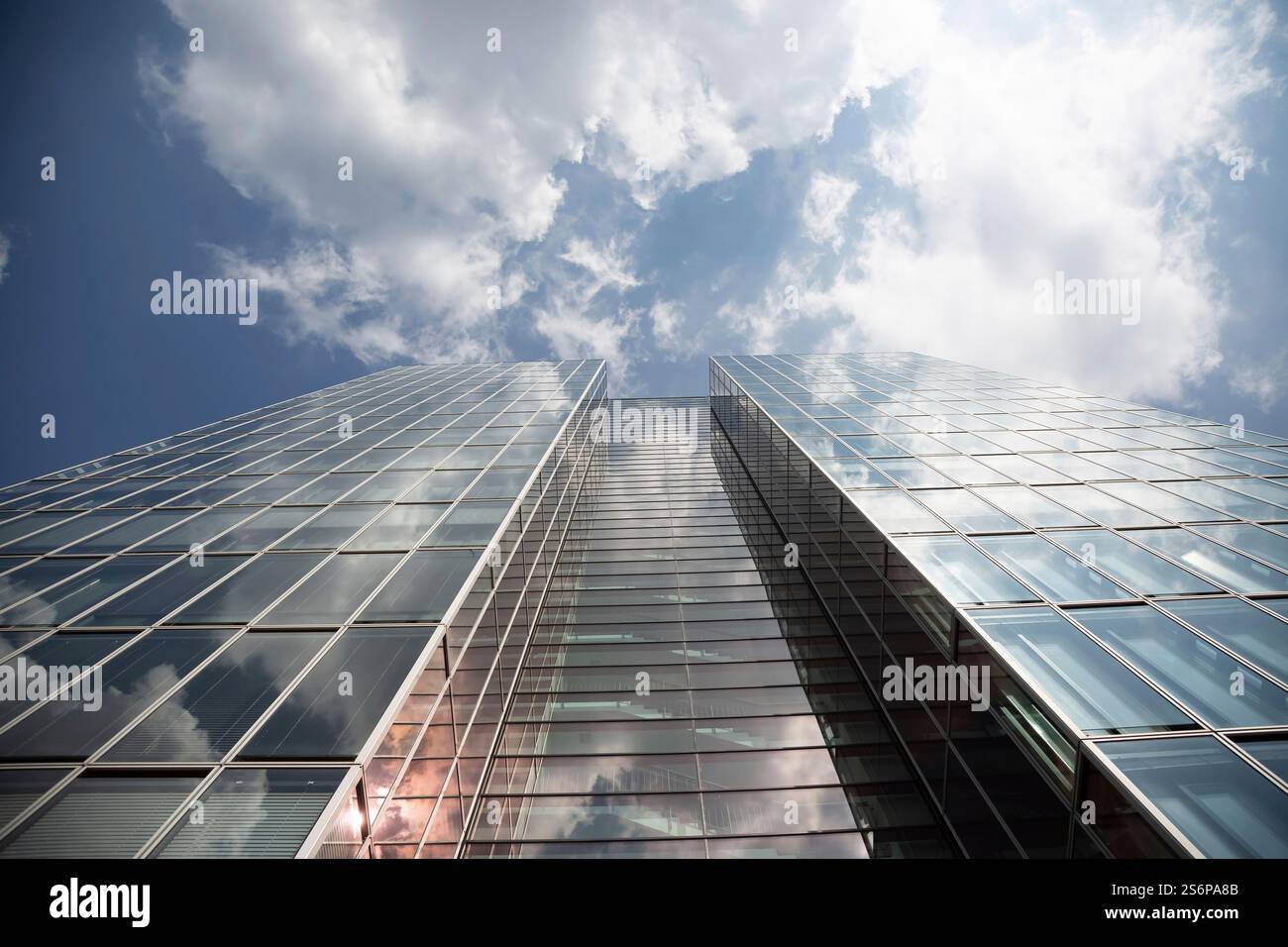 Modern office building from below with blue sky and white clouds ...