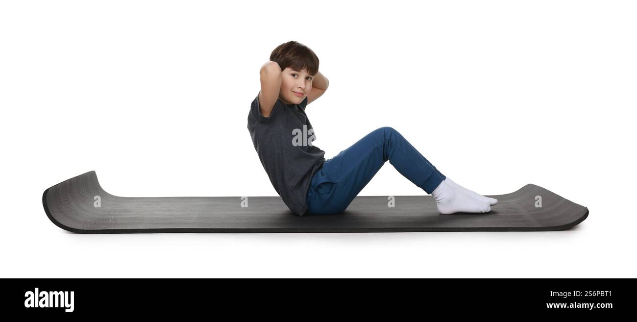 Boy exercising on fitness mat against white background. Sport activity ...