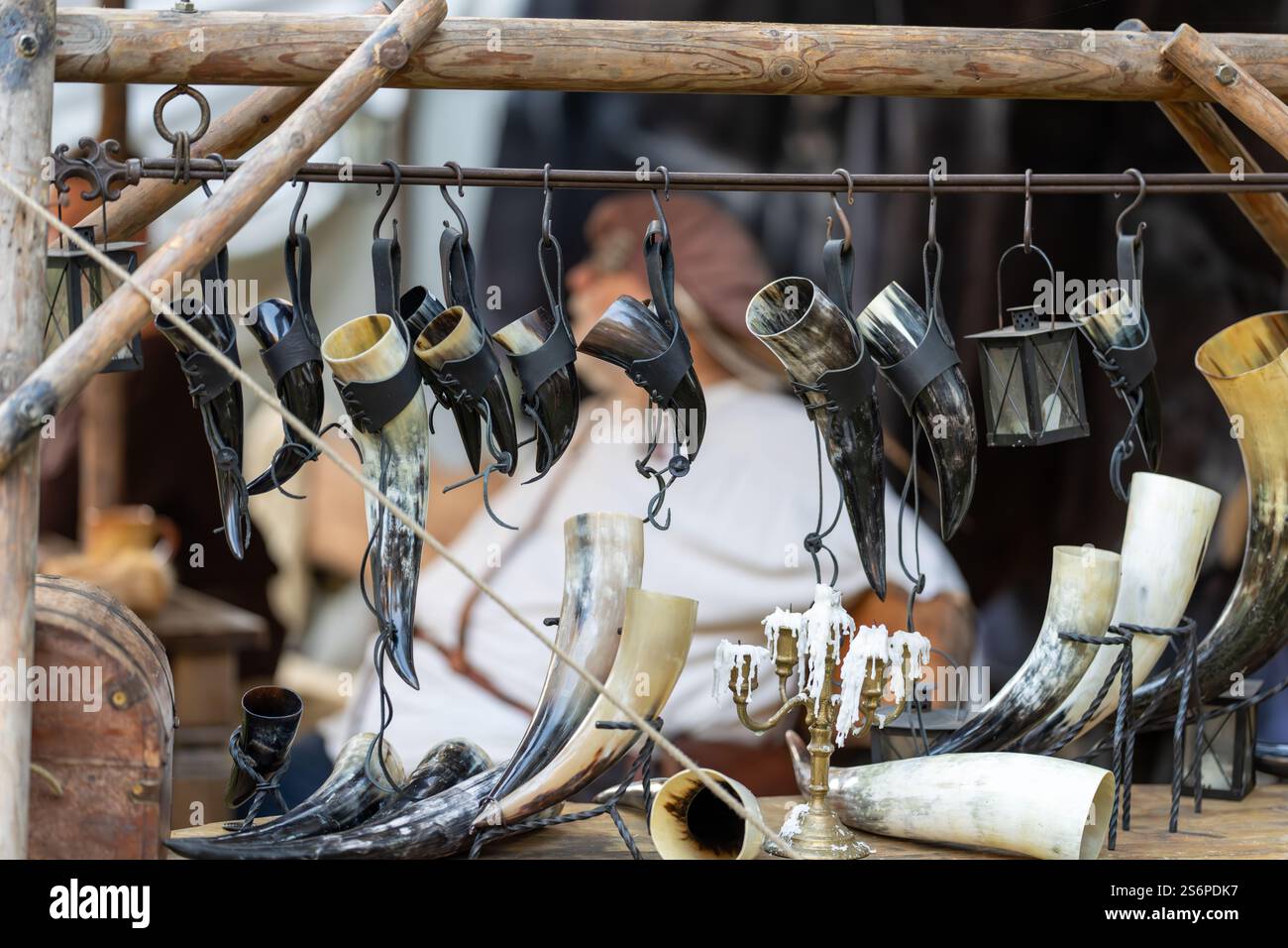 A display of horns and other items hangs from a wooden beam. The ...