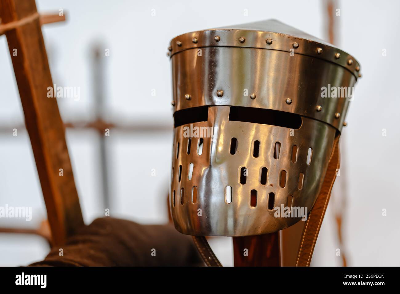 A knight's helmet with a metal face plate and a strap. The helmet is ...