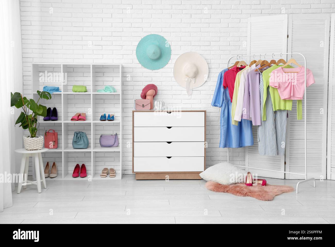 Stylish interior of dressing room with rack, chest of drawers and ...