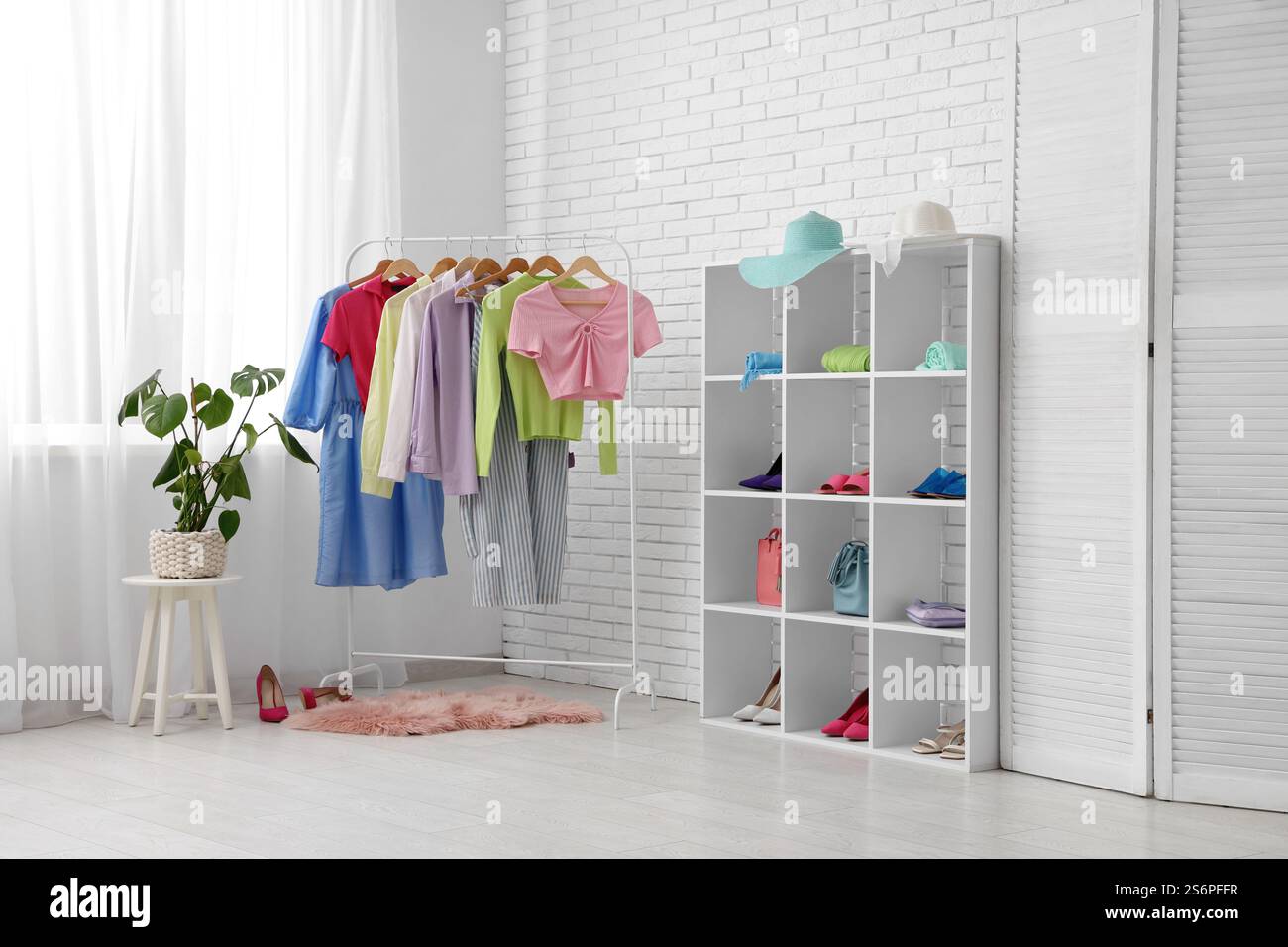 Stylish interior of dressing room with rack, folding screen and ...