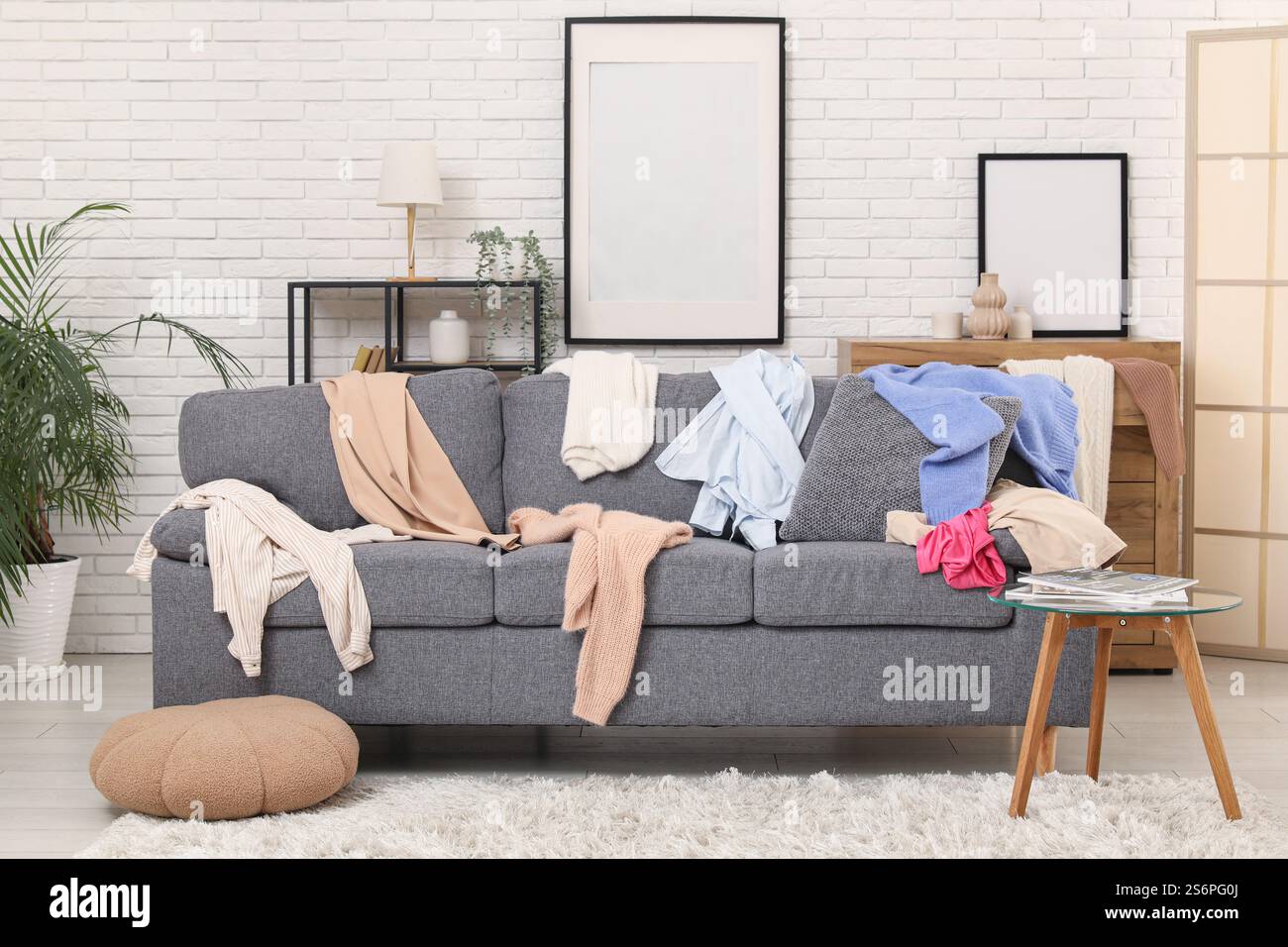 Interior of messy living room with grey sofa, coffee table and ...