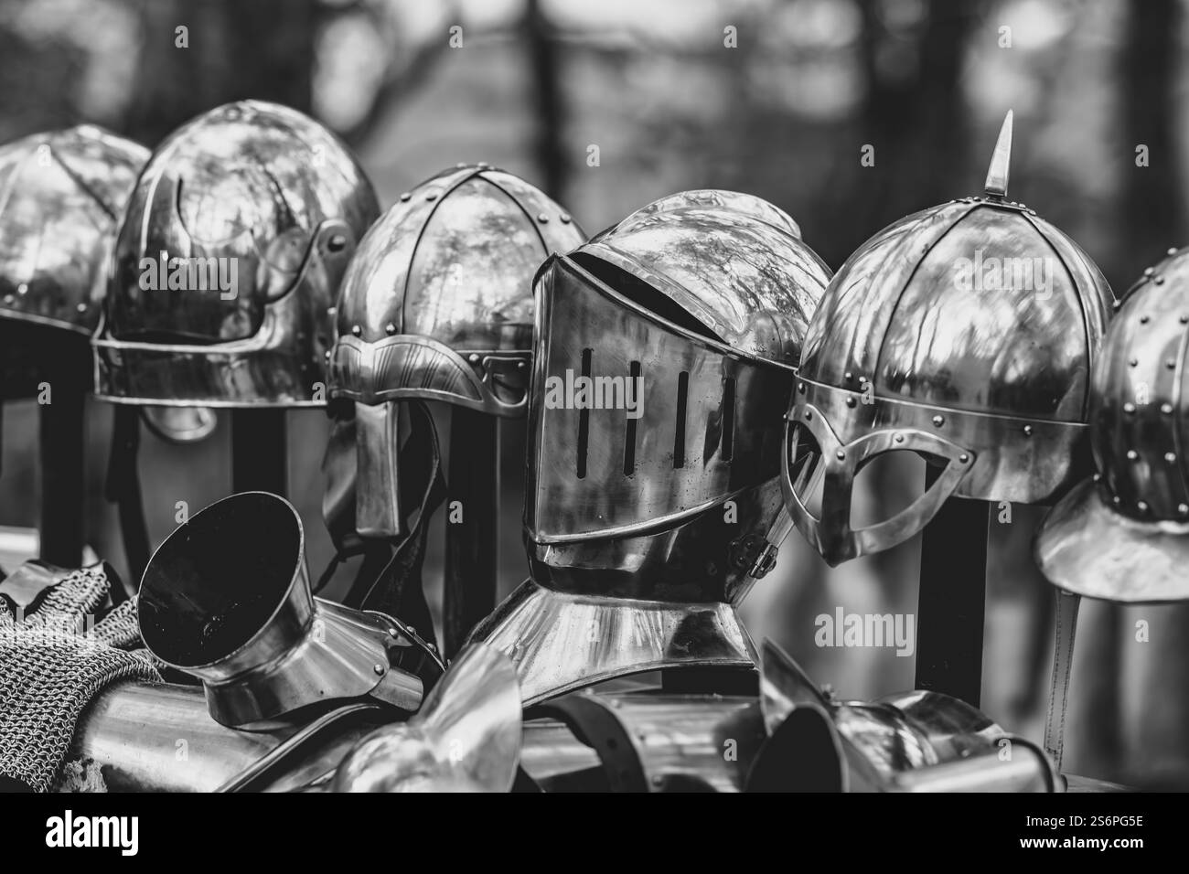 A row of helmets and shields are displayed in a museum. The helmets are ...