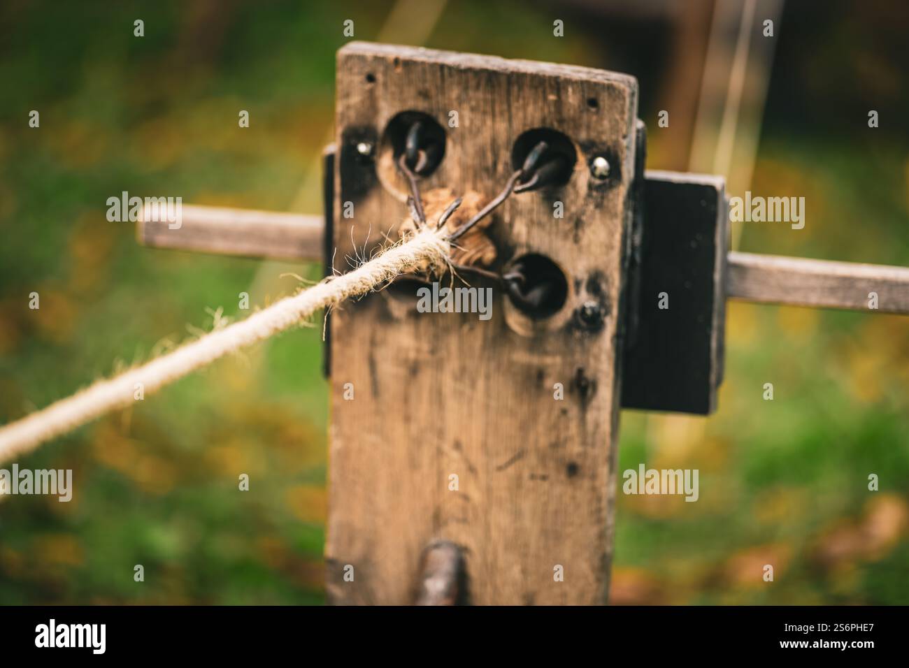 A wooden contraption with a rope attached to it. The contraption is old ...