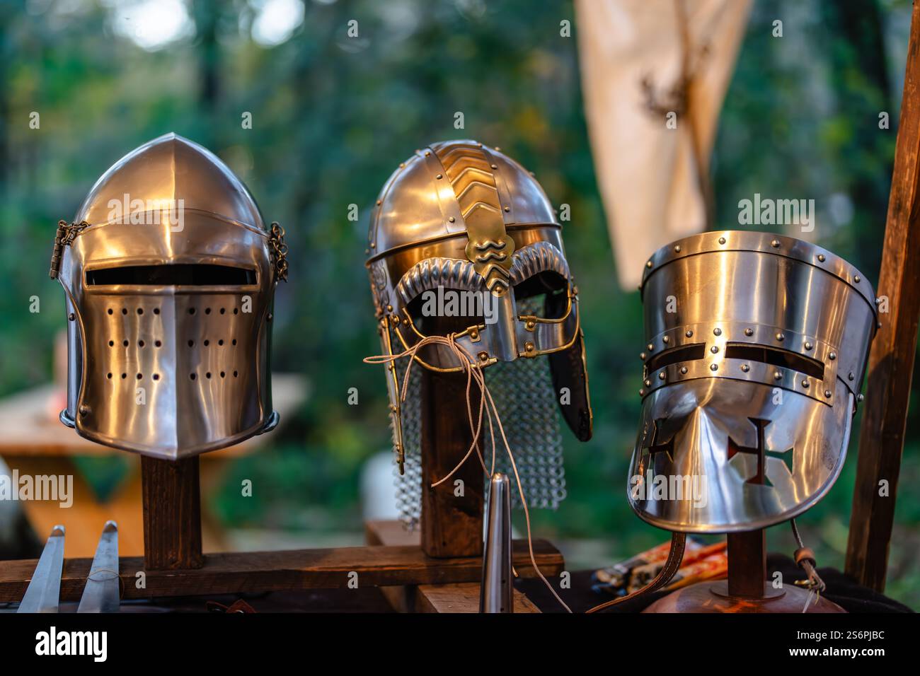 Three metal helmets are displayed on a wooden stand. The helmets are ...