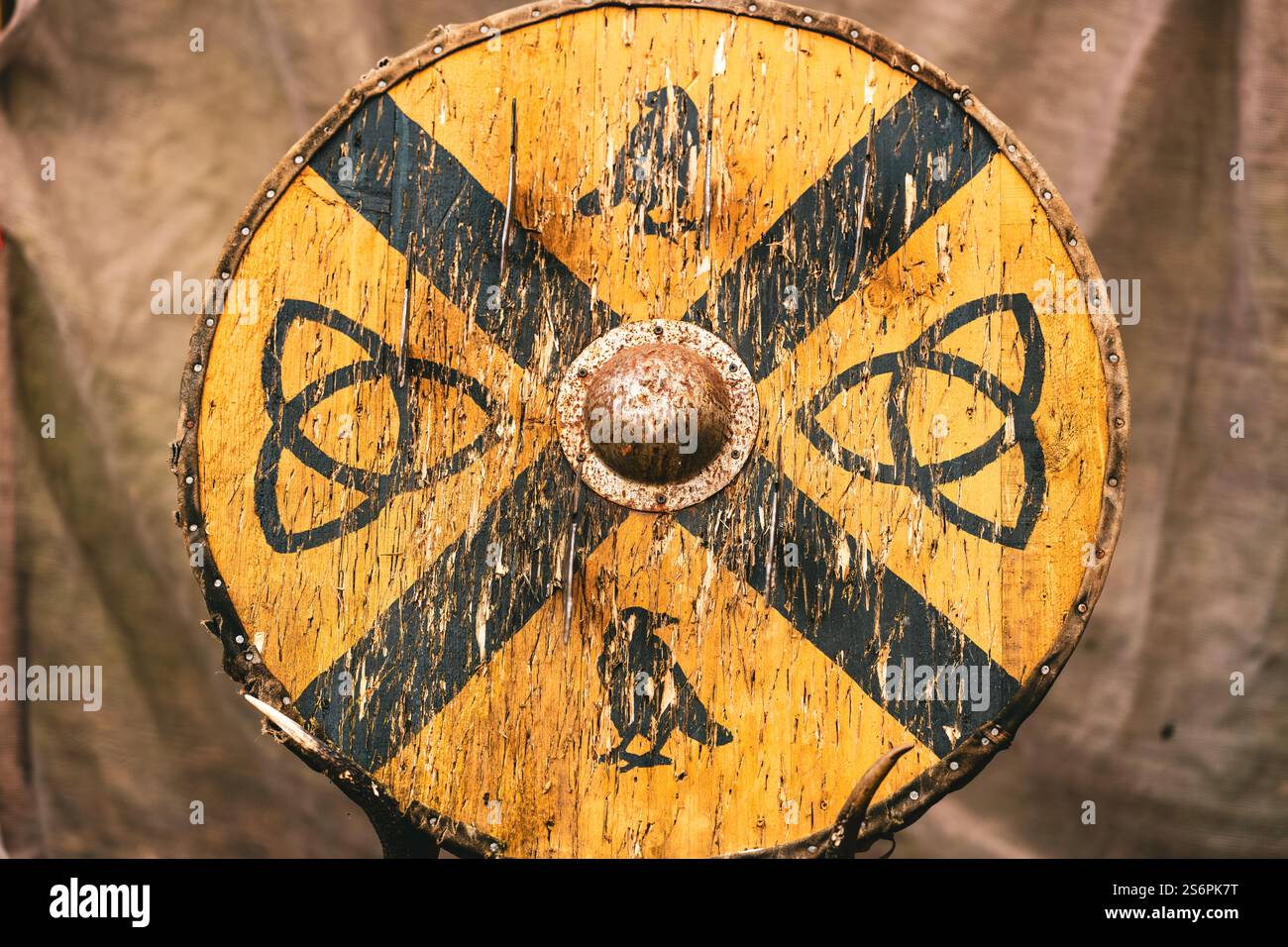 A battered and worn Viking shield with a cross on it. The shield is ...