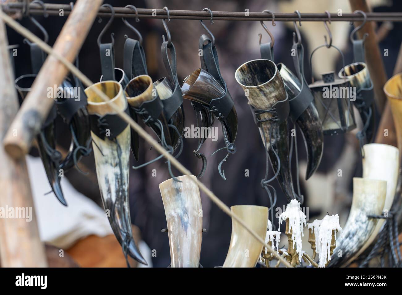 A display of horns and vases hanging from a rack. The vases are made of ...