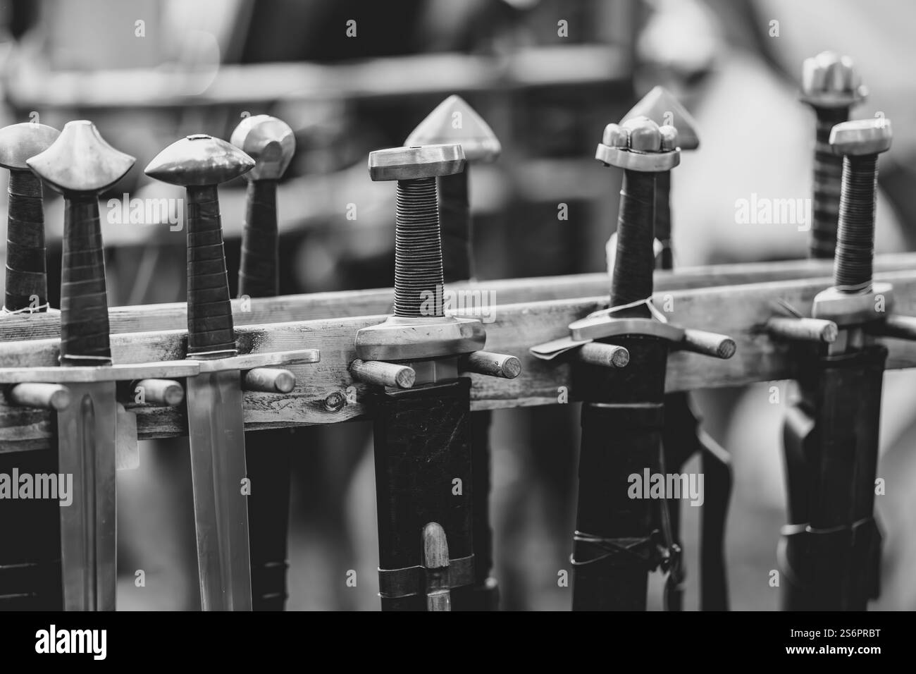 A row of swords are hanging on a rack. The swords are all different ...