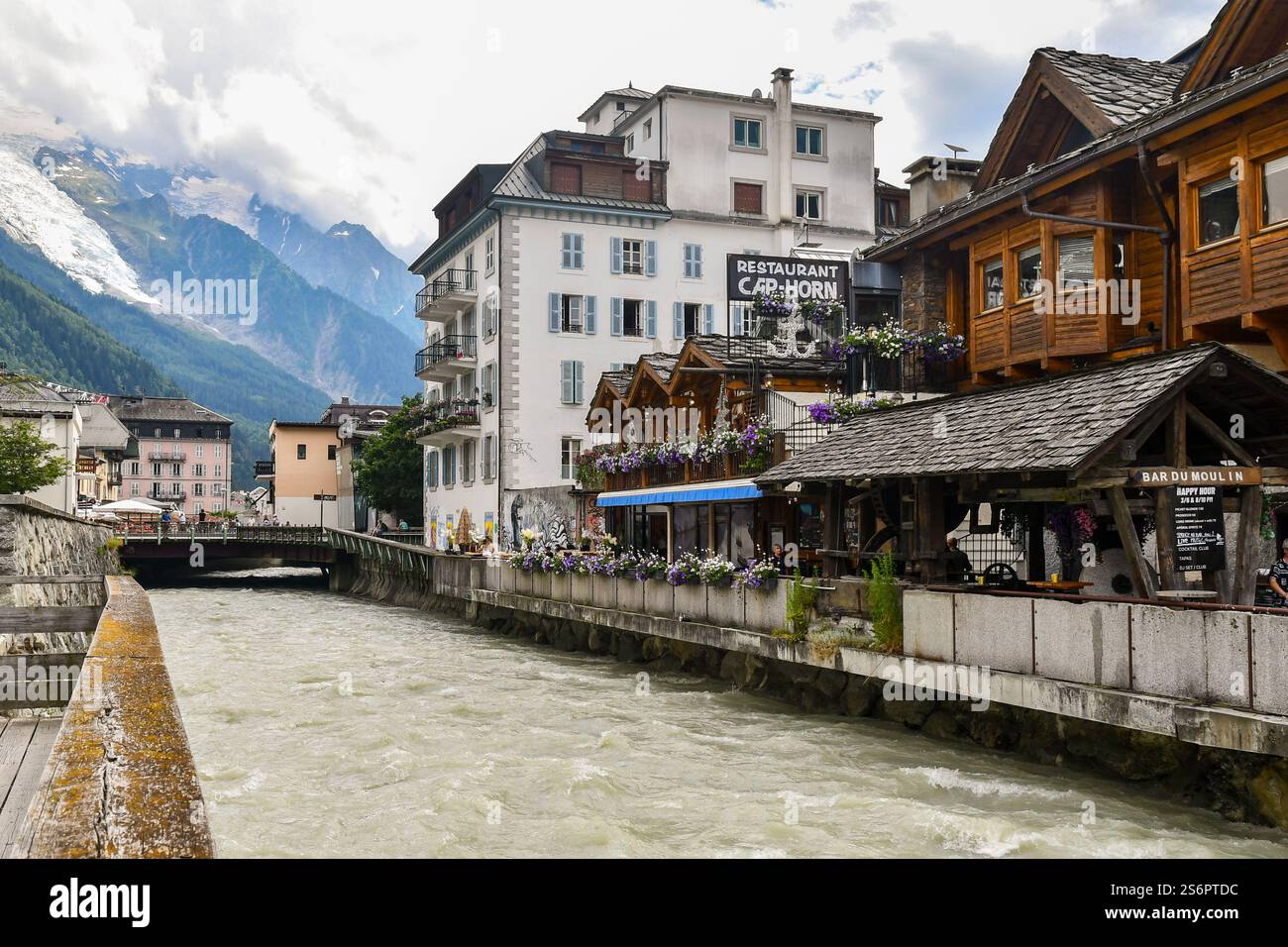 The Arve River crossing the centre of the Alpine town, with outdoor ...