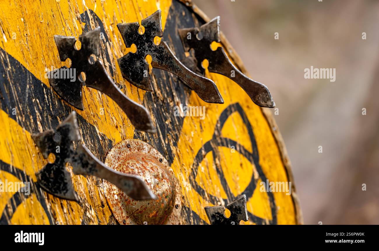 A yellow shield with a black cross on it and five black axes on it. The ...