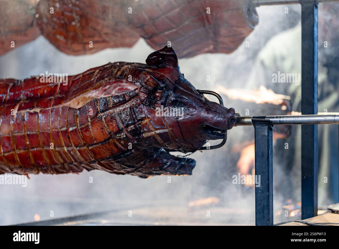 Cook's pig on a spit in the smoke over hot coals. Outdoor grill Stock ...
