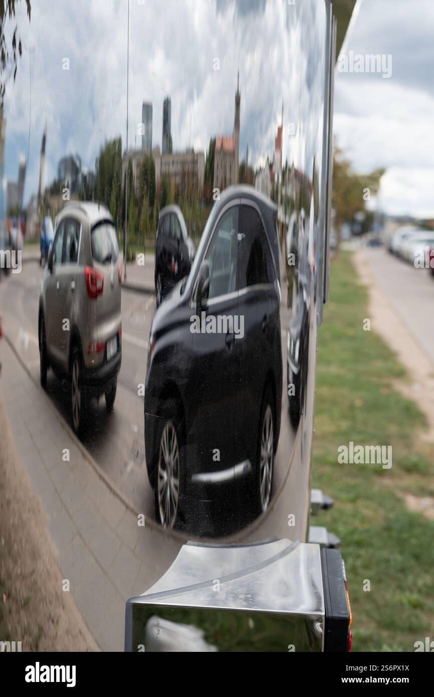 photo Reflective surface capturing urban street scene with parked ...