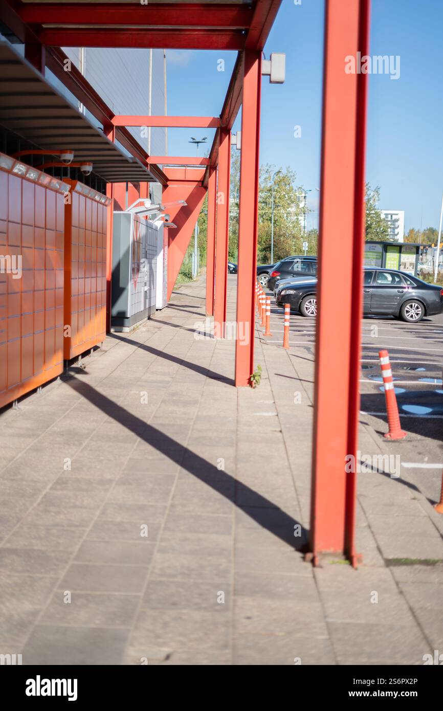 Modern urban delivery lockers in a parking area behind striking red ...