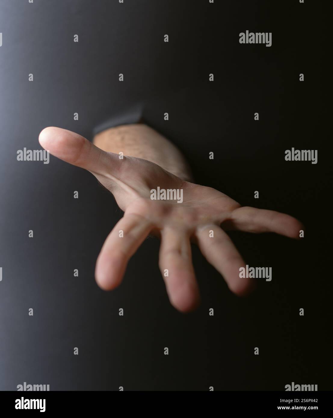 photo Outstretched hand reaching through a dark space symbolizing ...