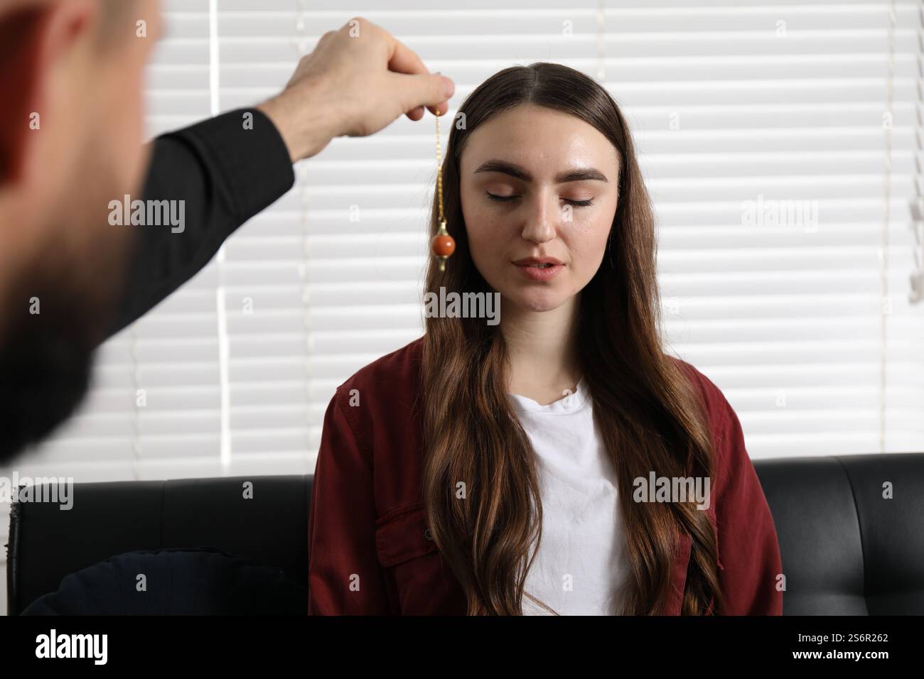 Psychologist using pendulum while working with patient during hypnosis ...