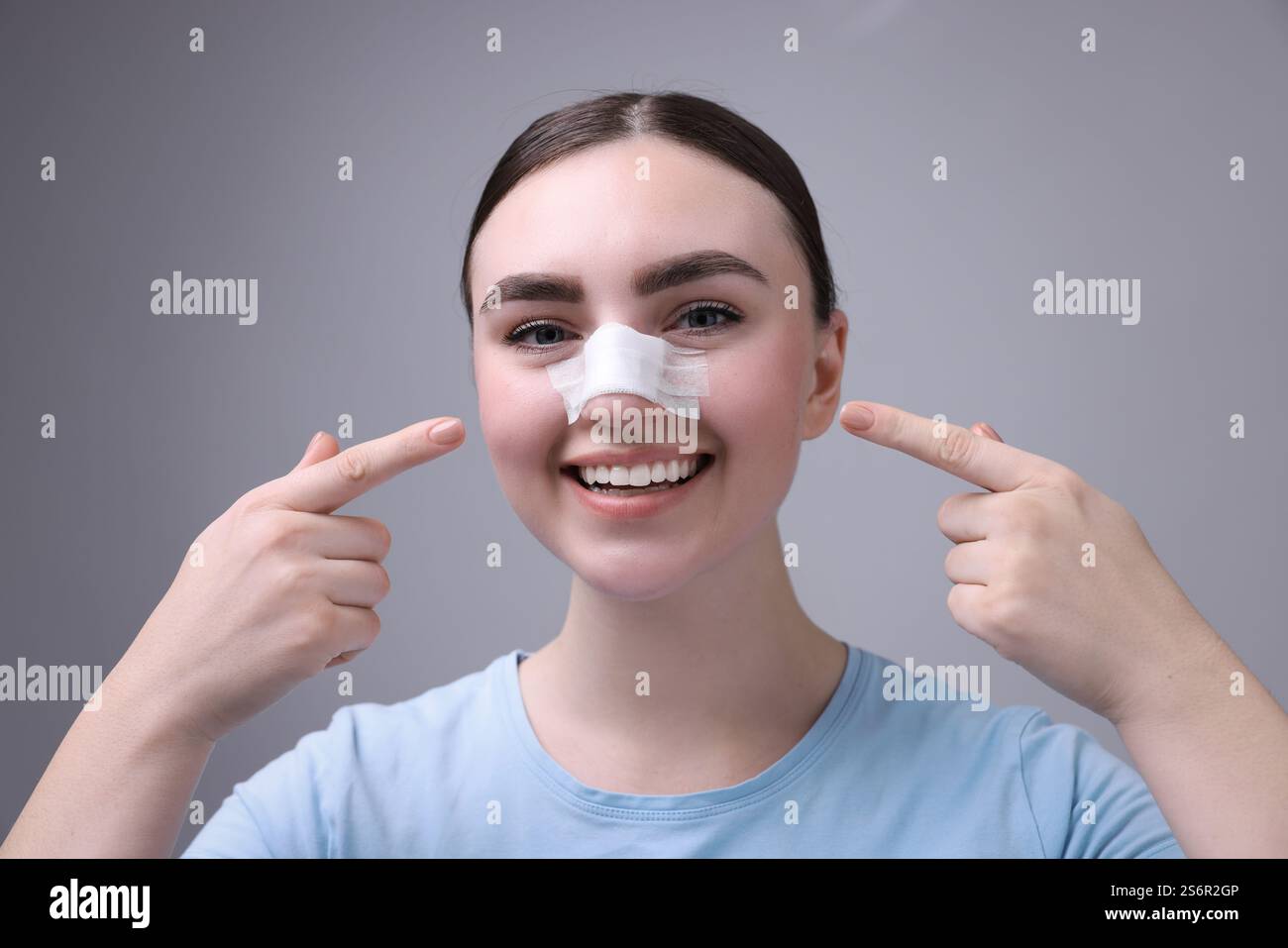 Woman with medical bandage on her nose after plastic surgery operation ...