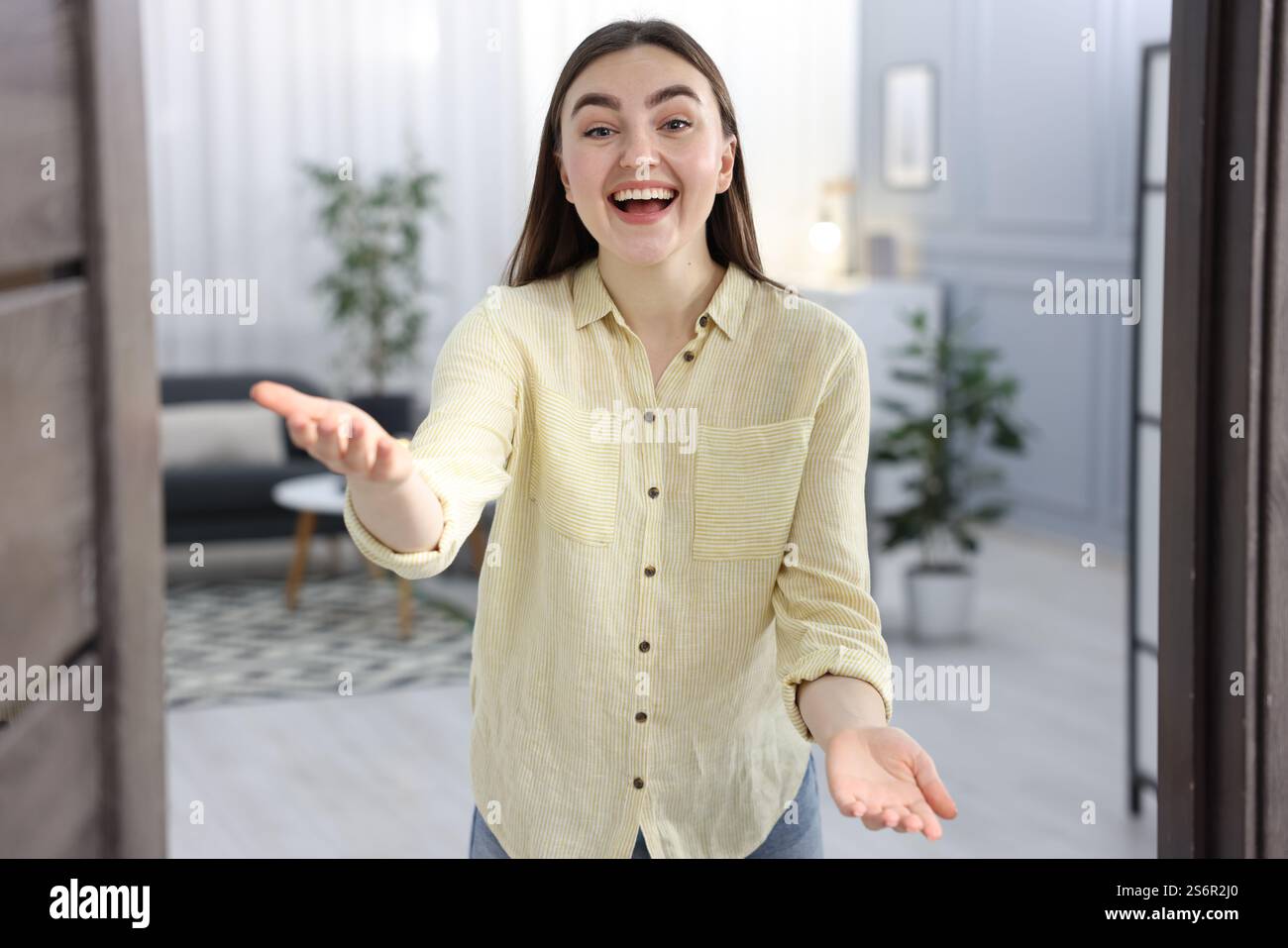 Happy woman welcoming guests to her house Stock Photo - Alamy