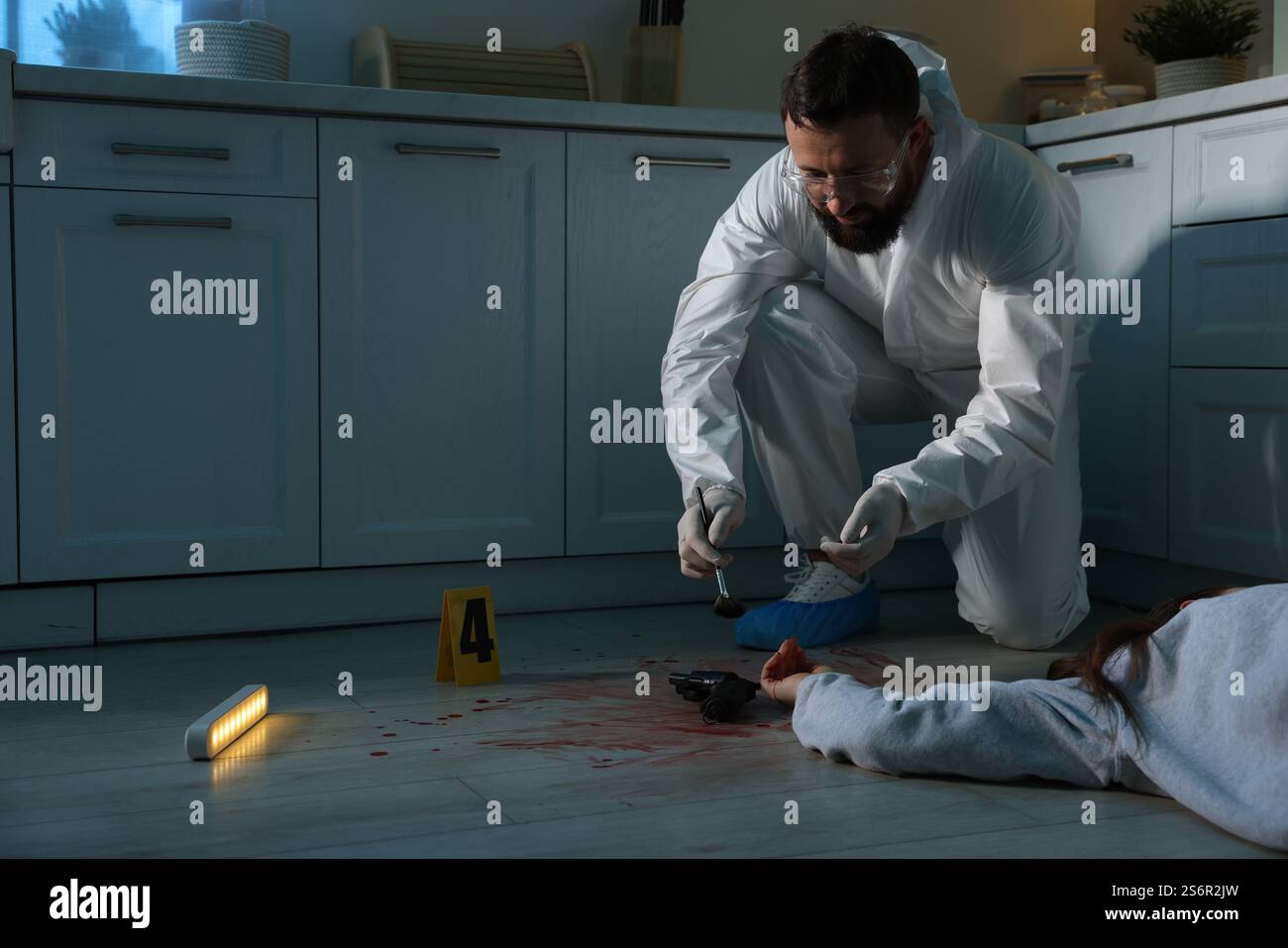 Forensic expert taking fingerprints with brush from gun and dead body ...