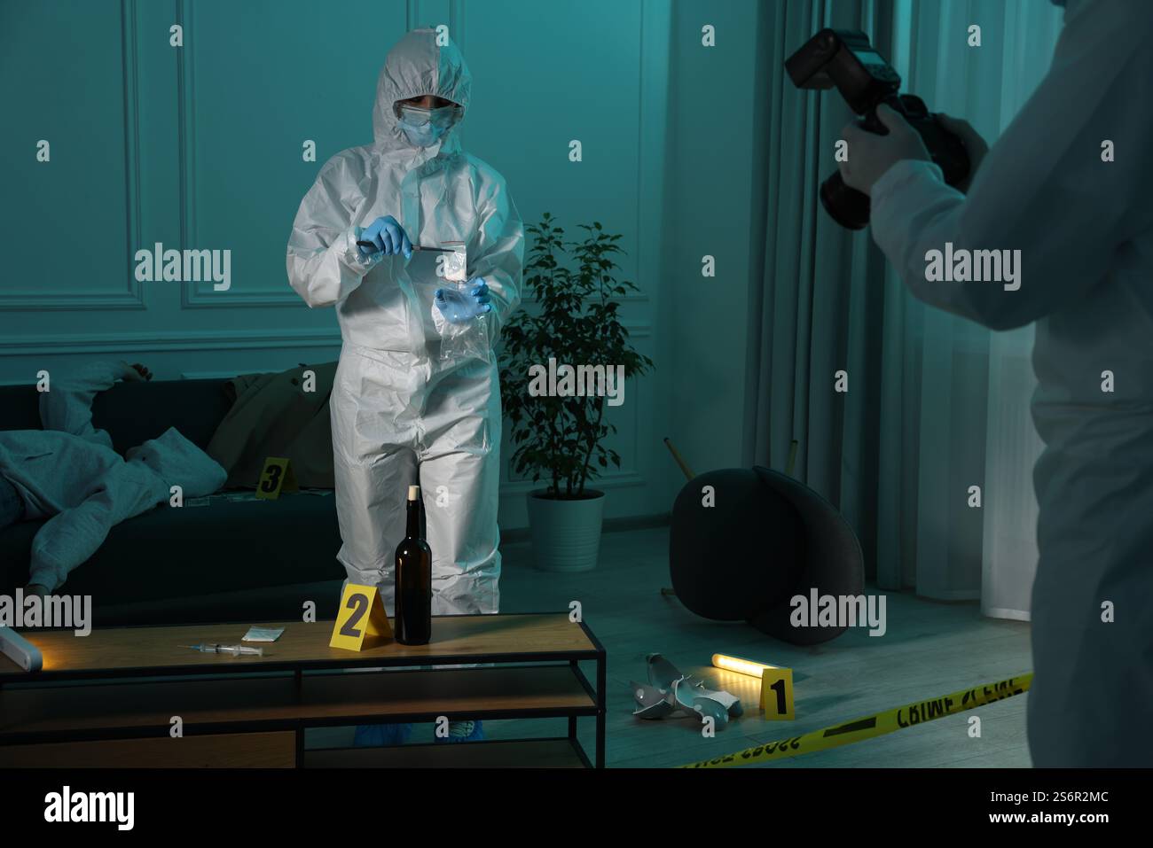 Forensic experts working at crime scene with dead woman's body indoors ...