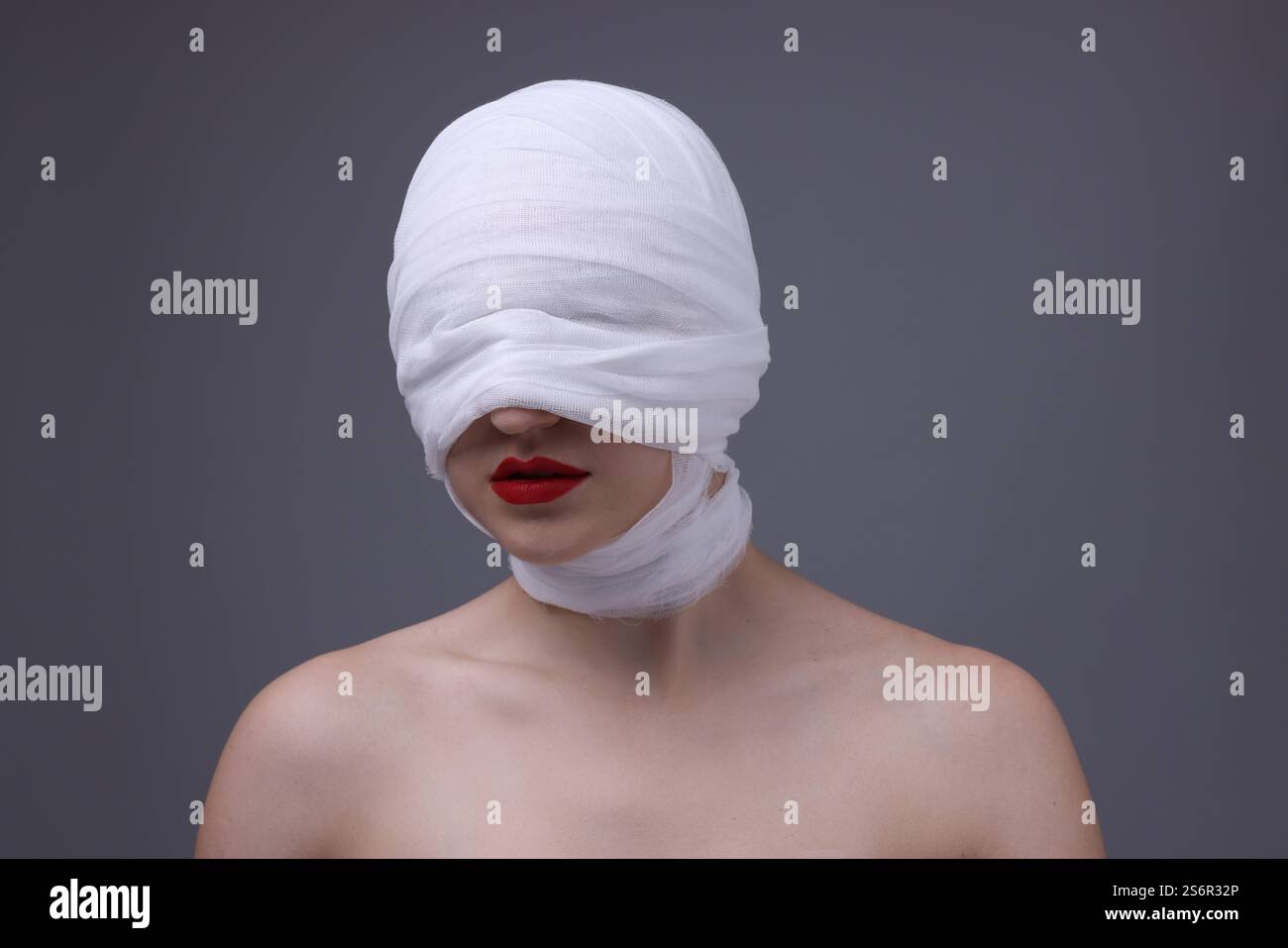 Woman with face wrapped in medical bandage after plastic surgery ...