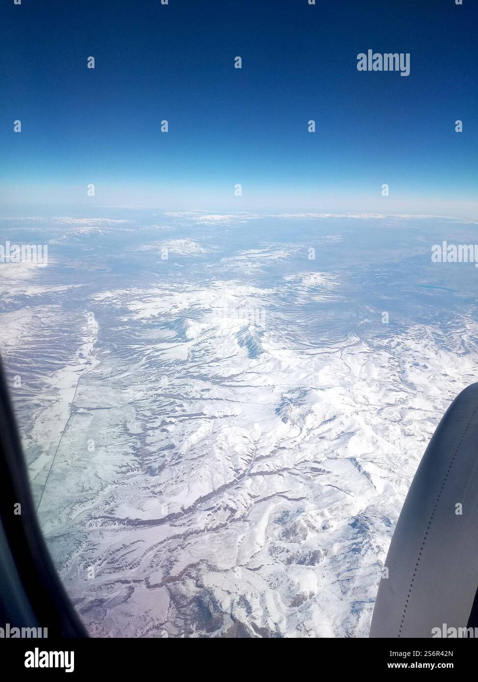 Window view of airplane flying over snowy mountains of Vancouver Canada ...