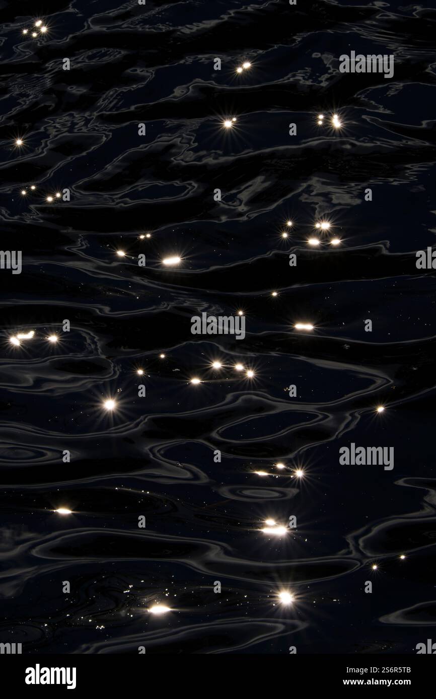 Light reflections caused by sunlight on the surface of a lake, small ...