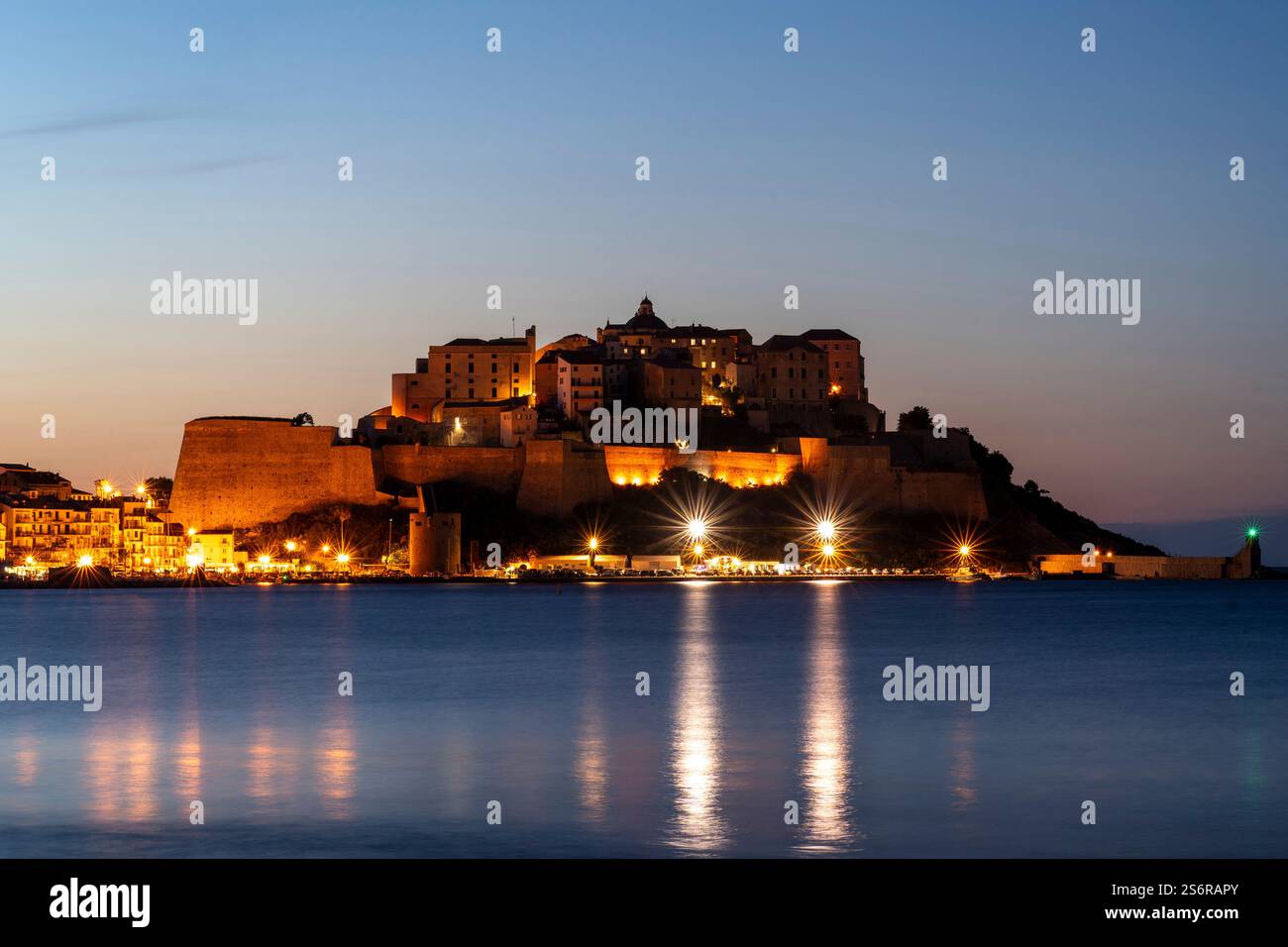 The town of Calvi at sunset, the illuminated citadel towers over the ...