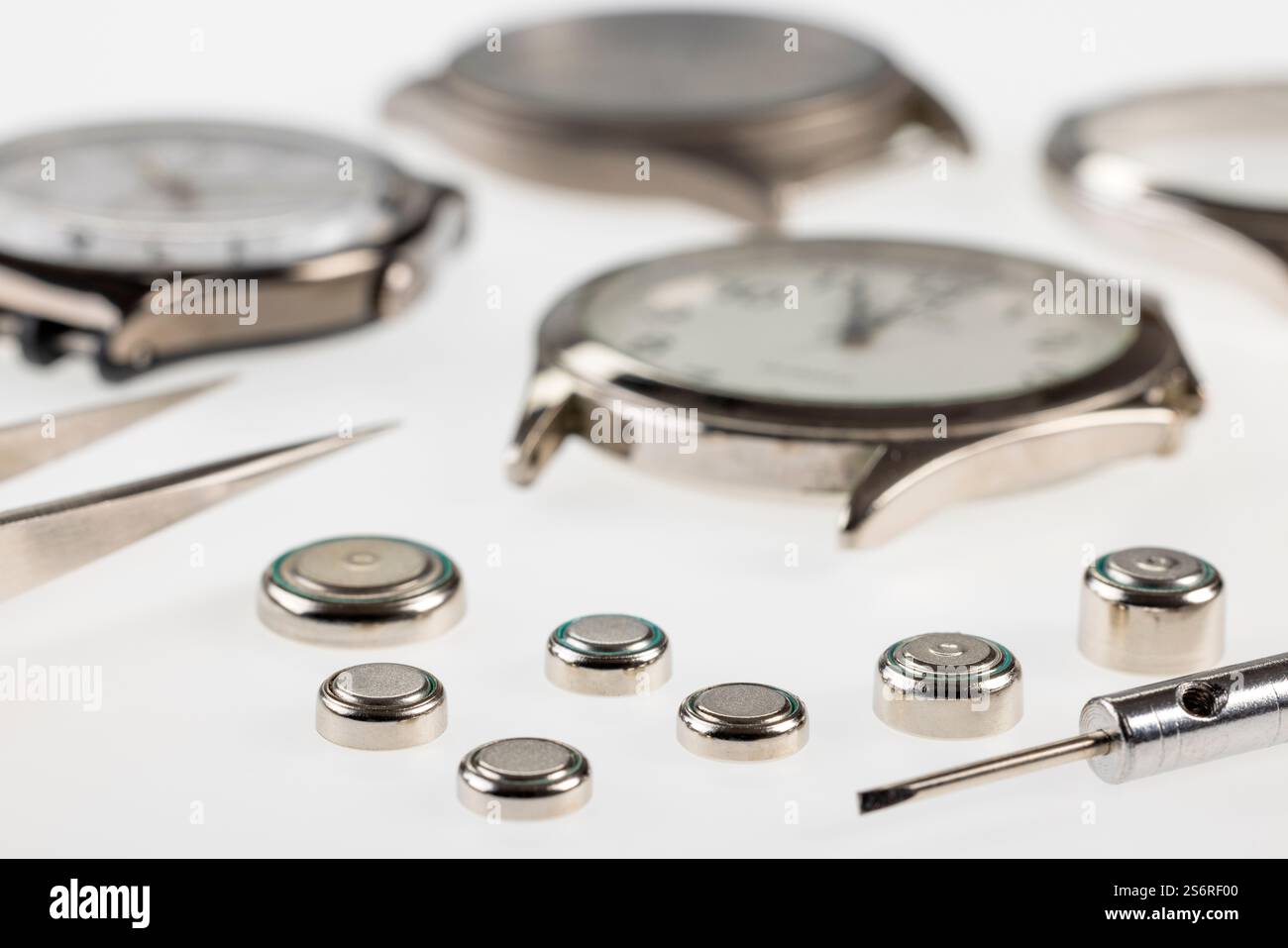 Watch batteries, various sizes, wristwatches, watchmaker's tools, white background, symbol photo ...