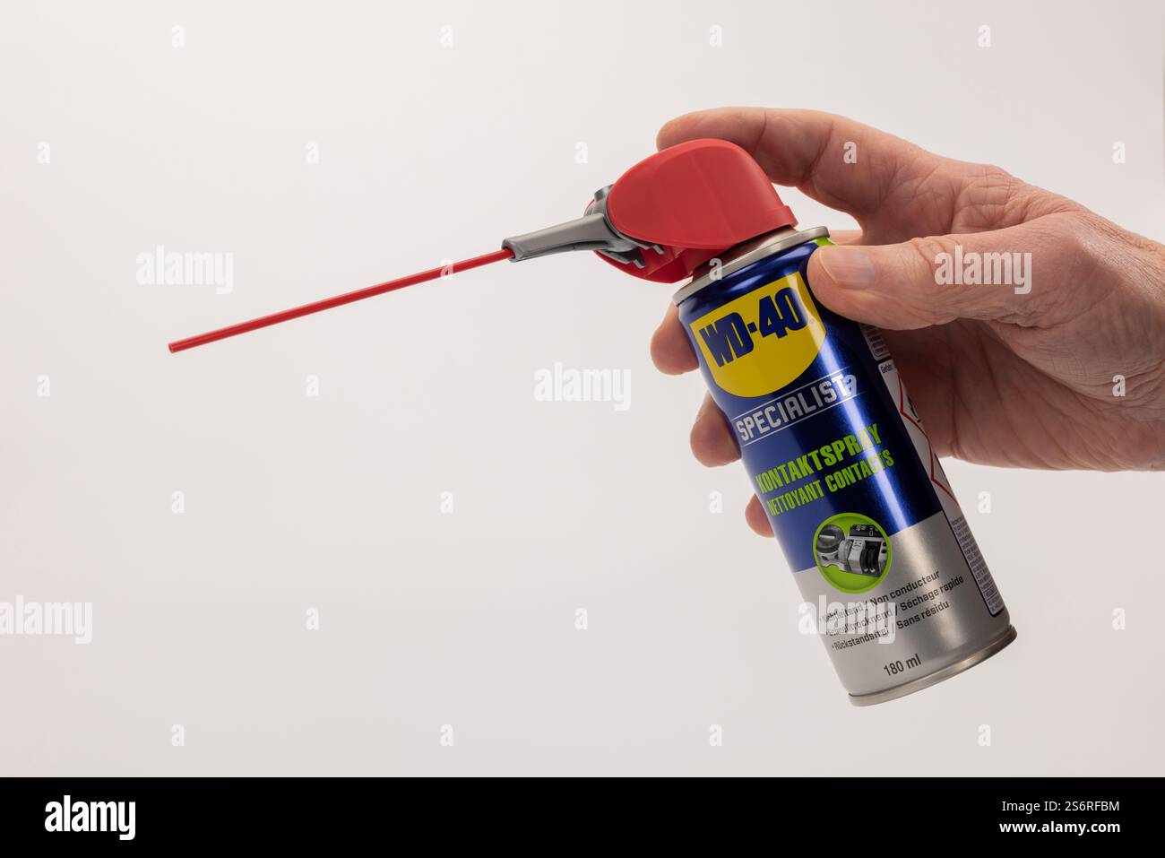Man's hand holding WD-40 SPECIALIST contact spray, white background ...