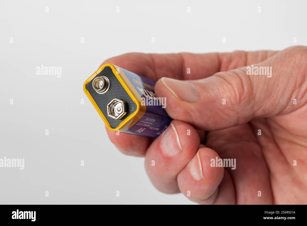 Man's hand holding new VARTA 9 volt block battery, white background ...
