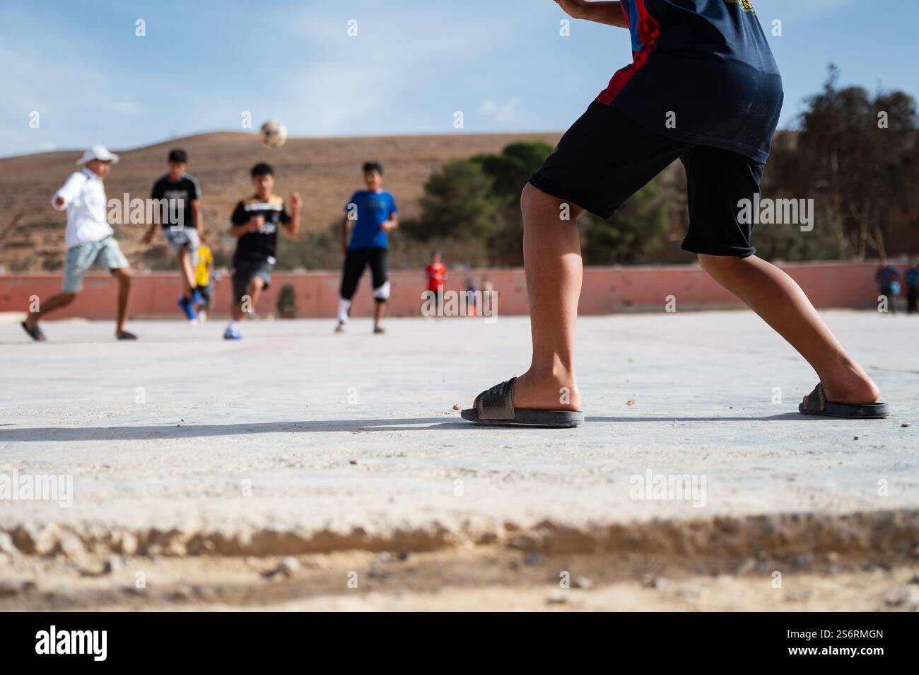 Legs of a boy playing football in flip-flops Stock Photo - Alamy
