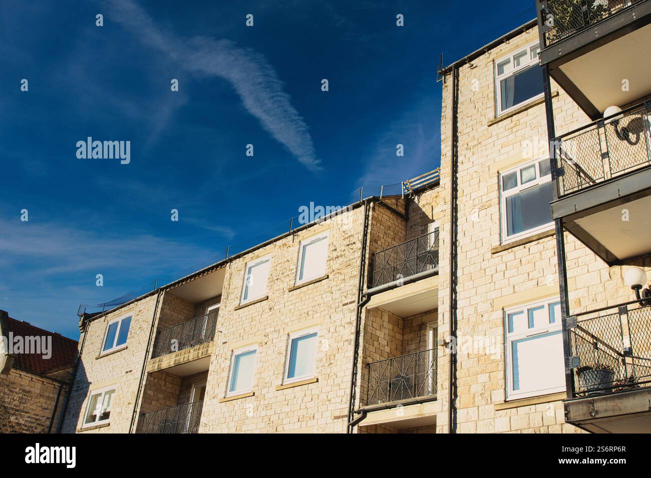 Low-angle view of a light beige stone apartment building with multiple ...