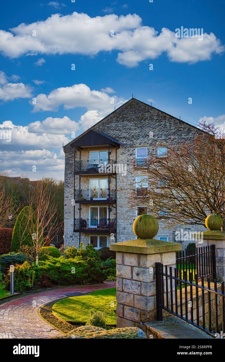 Three-story stone apartment building with balconies, situated in a ...