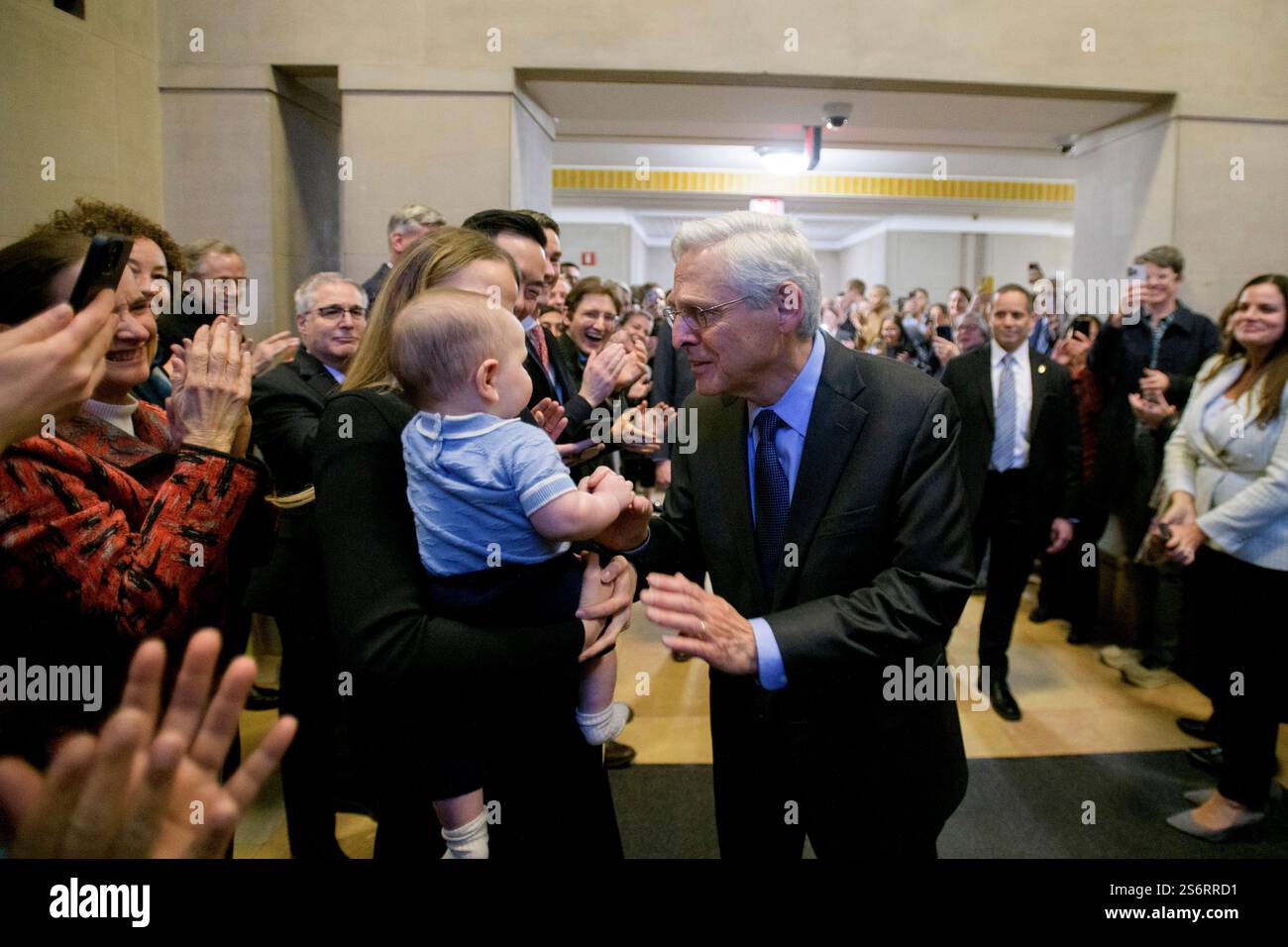 Attorney General Merrick Garland greets a baby as he receives a "clap ...