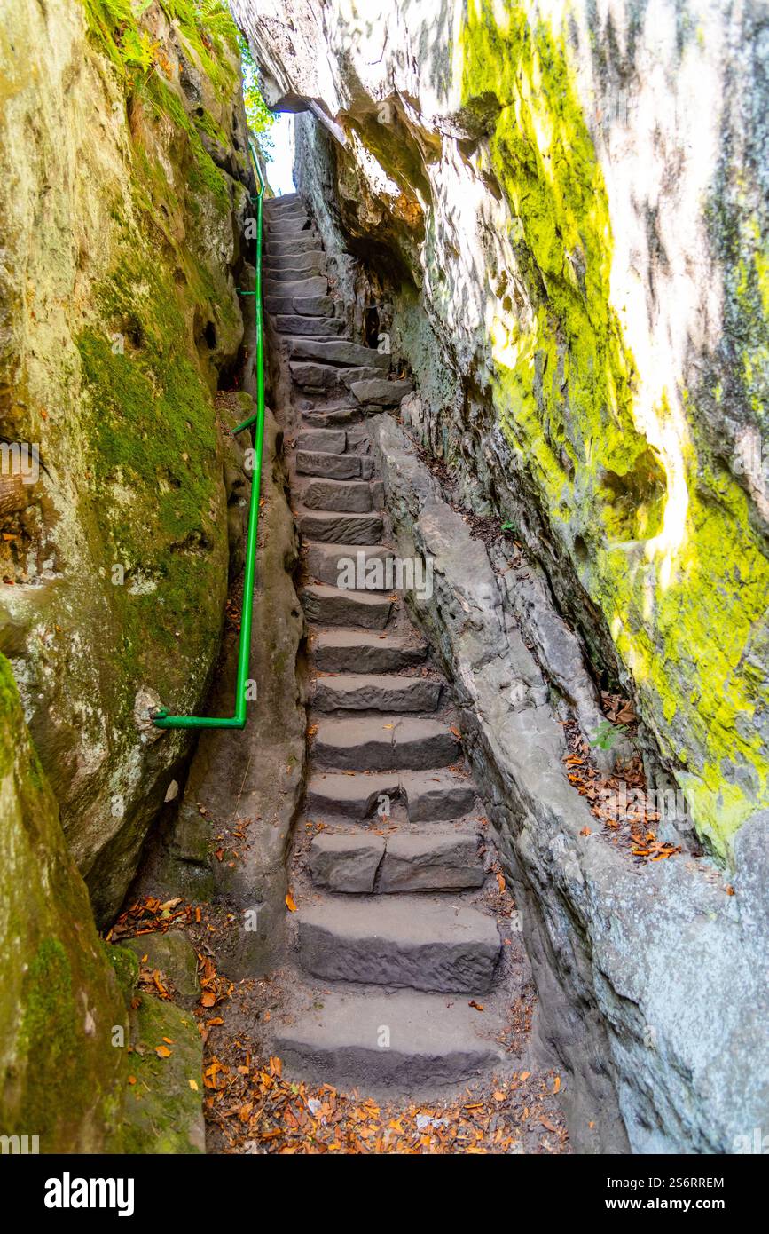Worn stone steps ascend through narrow sandstone rocks, illuminated by ...
