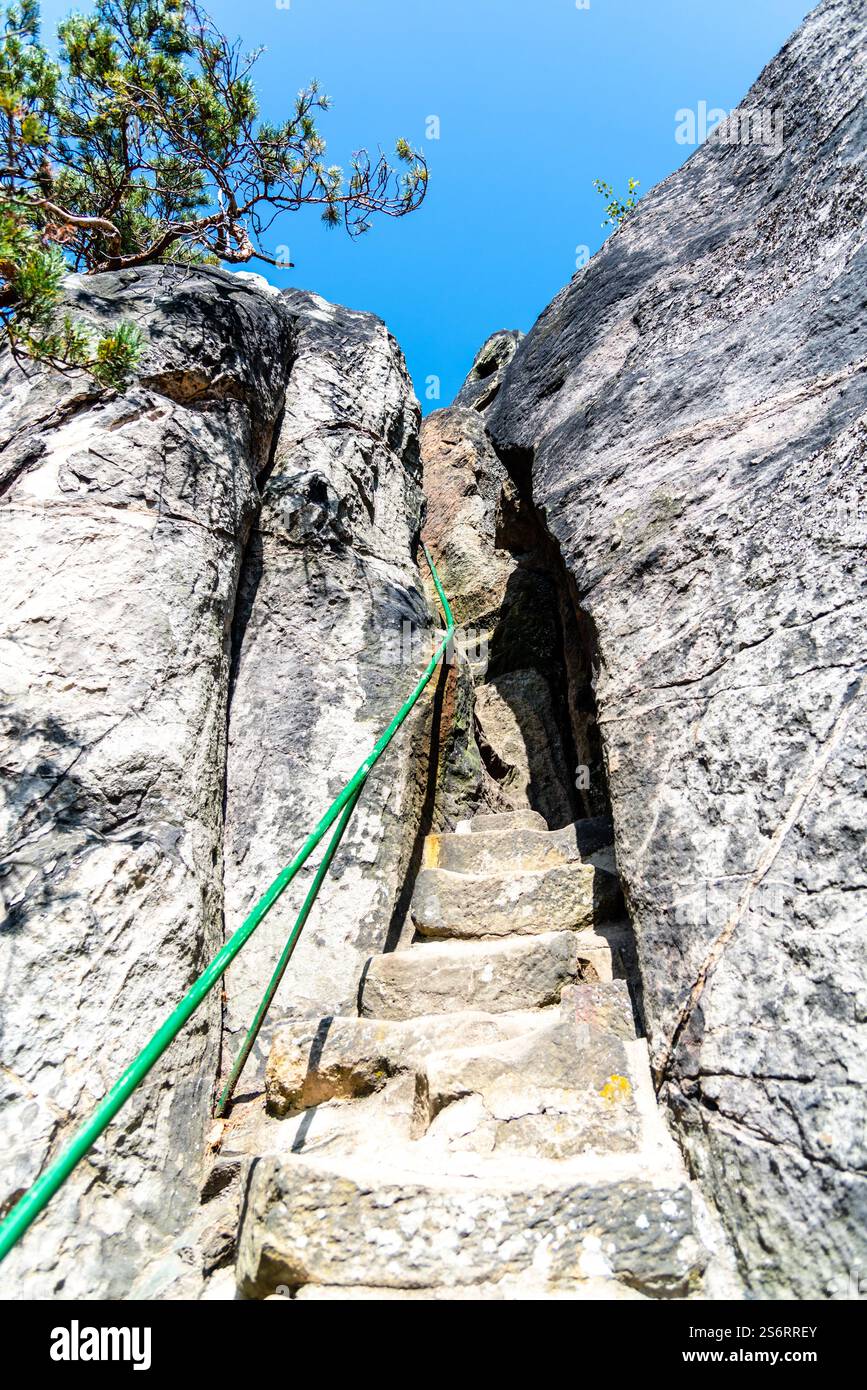 A winding pathway through narrow sandstone rocks ascends towards a ...