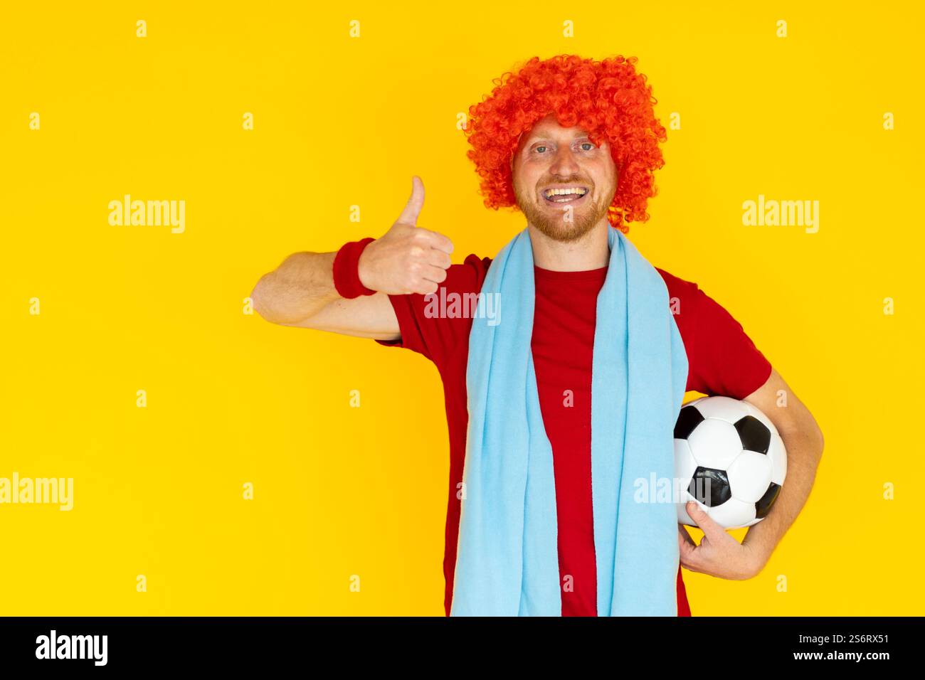 Football fan showing thumbs up while holding ball Stock Photo - Alamy