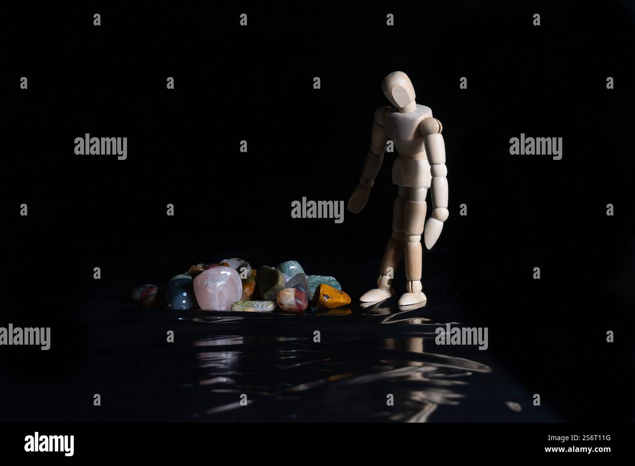 Wooden Person Standing Over Colorful Stones Stock Photo - Alamy