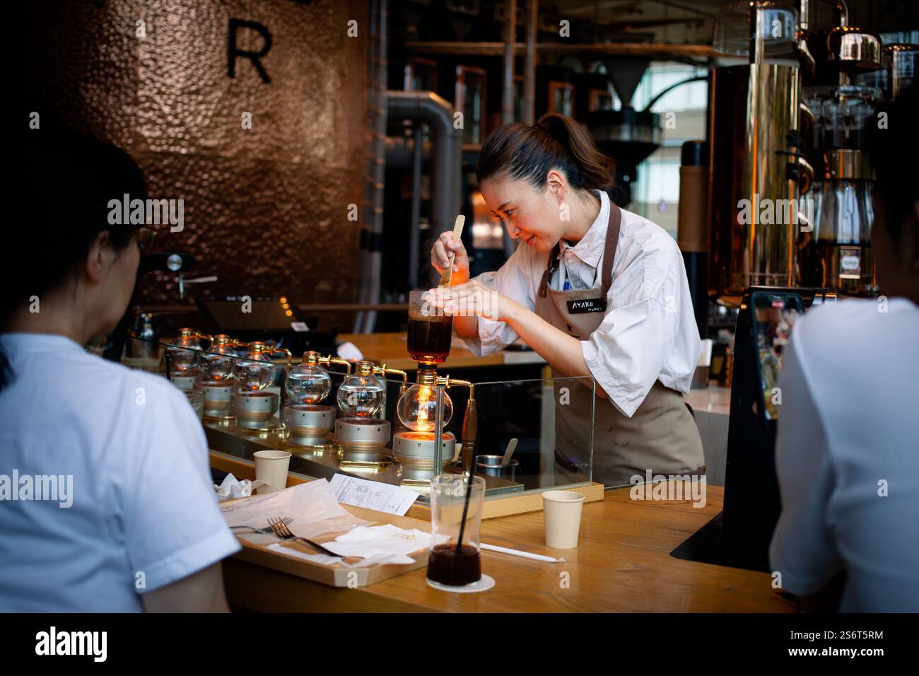 a female barista making coffee inside the largest Starbuck roastery in ...