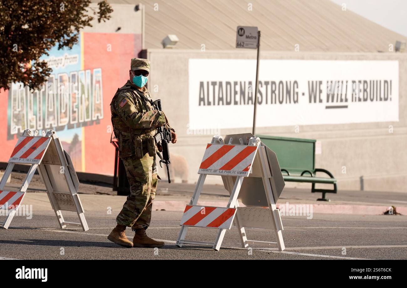 A National Guard soldier patrols Lake Avenue in front of a recently ...
