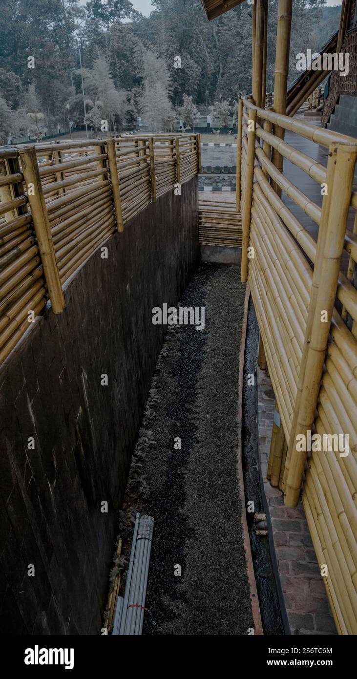 A narrow pathway with bamboo railings on both sides, leading to a ...