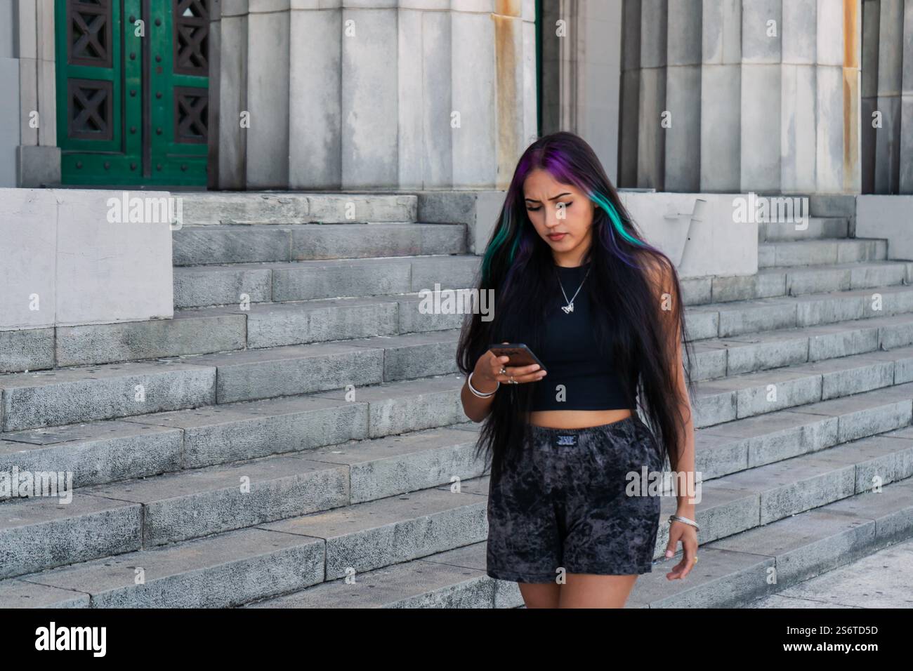 Young woman walking along the steps while checking and answering cell phone messages Stock Photo ...