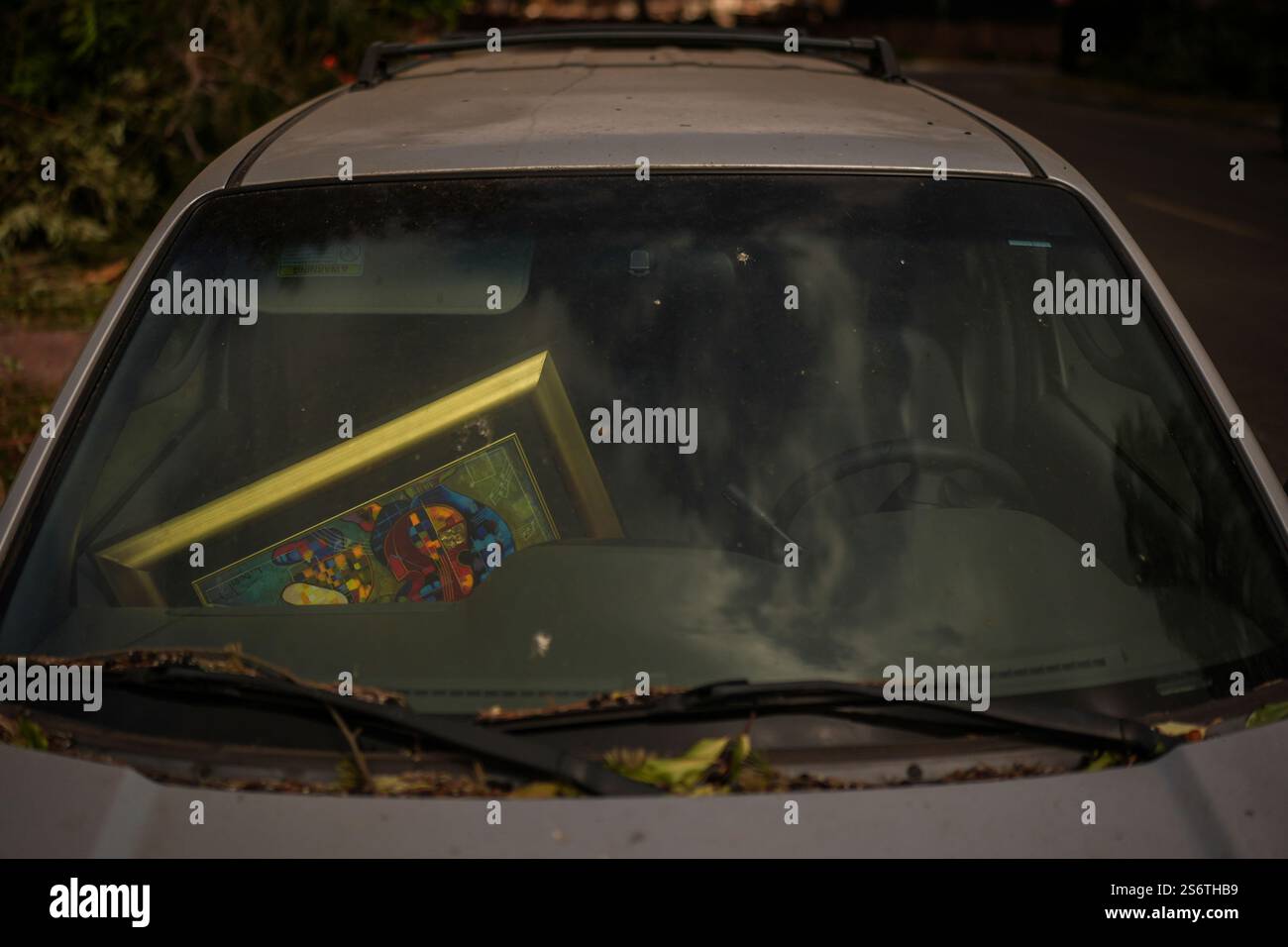 A framed painting rests inside a vehicle along with other belongings in ...