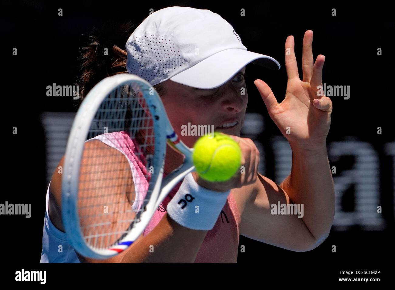 Iga Swiatek of Poland plays a forehand return to Emma Raducanu of ...