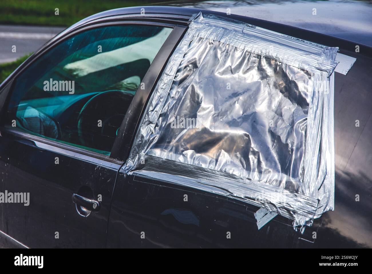Car window repaired with plastic and tape after theft Stock Photo - Alamy