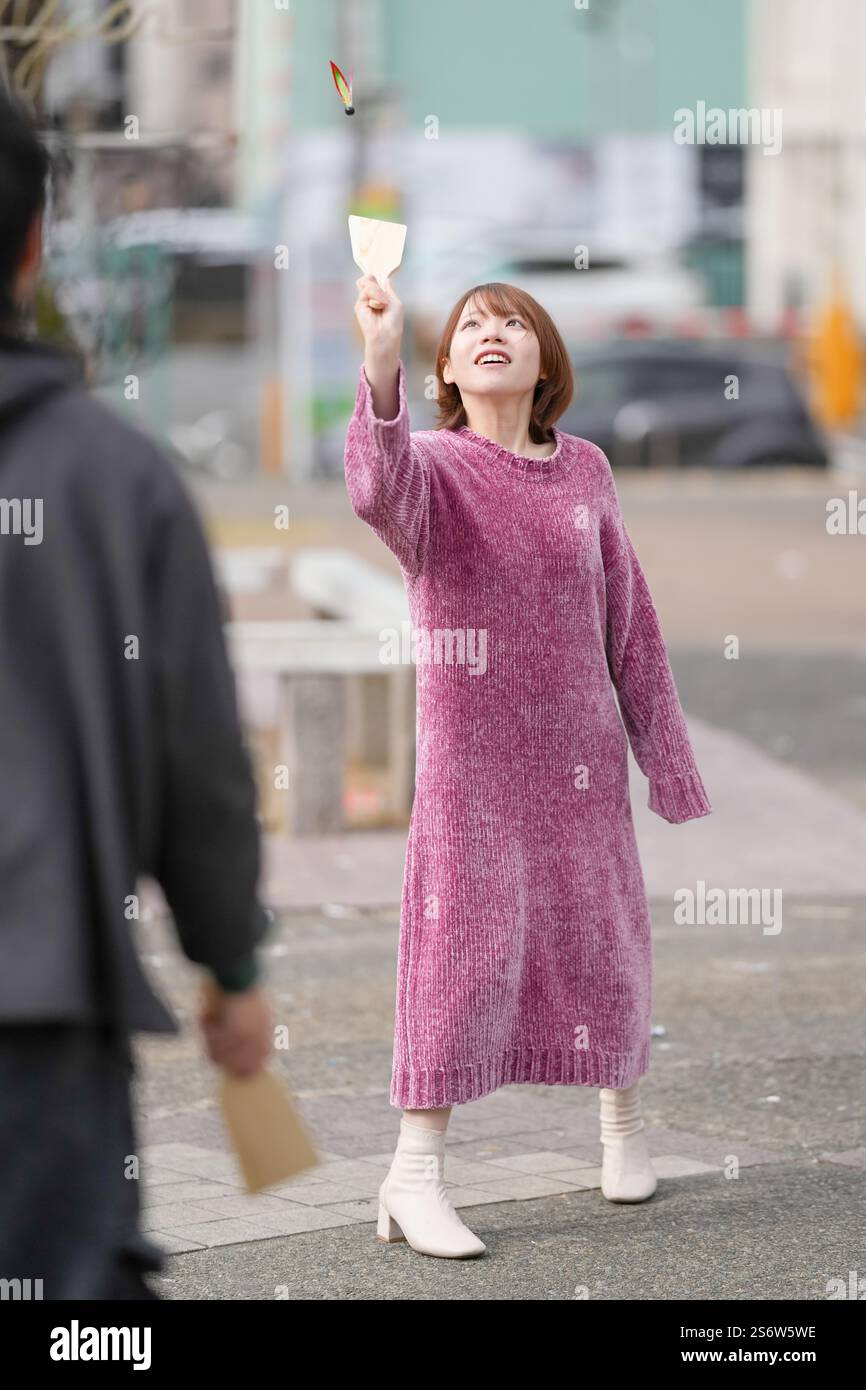 A Japanese man and woman in their 20s are playing hagoita, a ...