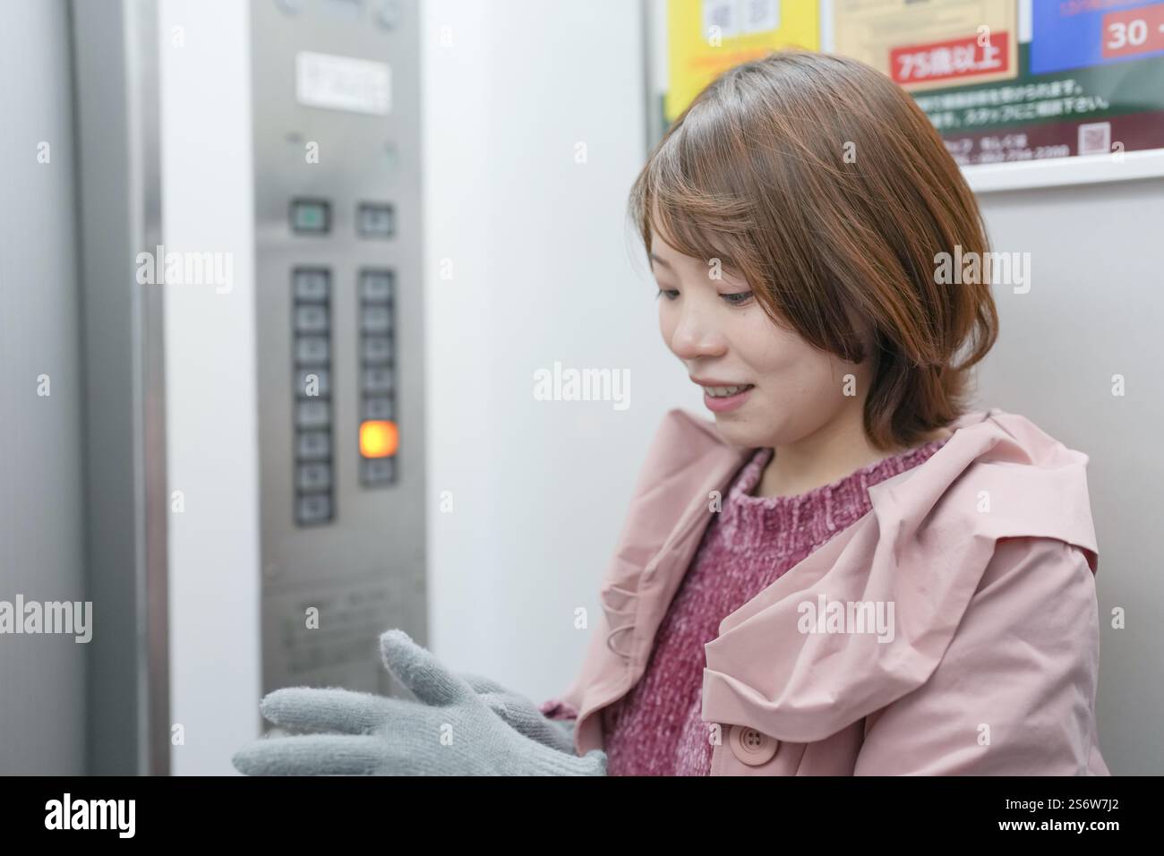 A Japanese man and woman in their 20s ride an elevator in a multi ...