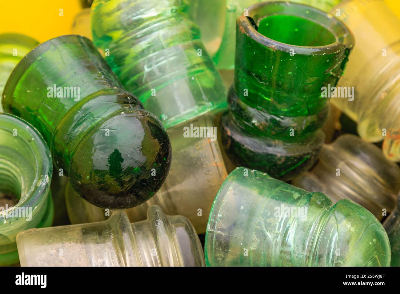 A pile of green and white glass jars. The jars are all different sizes ...